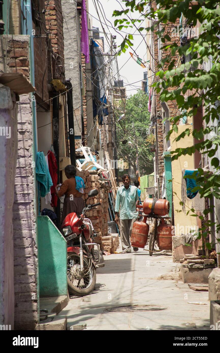 A man in a cluttered alleyway in the Delhi slums, India Stock Photo - Alamy