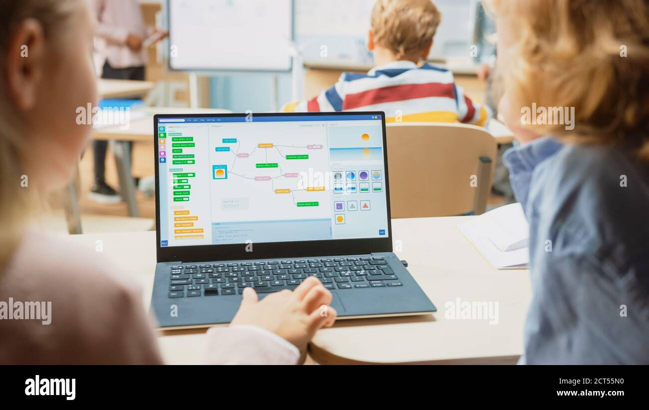 Elementary School Science Class: Over the Shoulder Little Boy and Girl Use Laptop with Screen ...