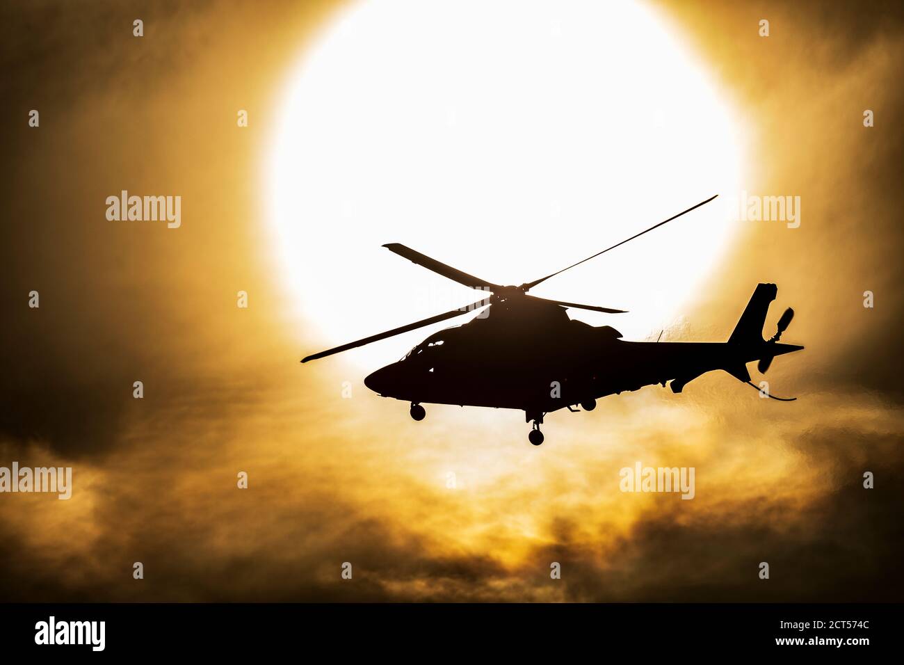 Helicopter silhouette against the sun Stock Photo - Alamy