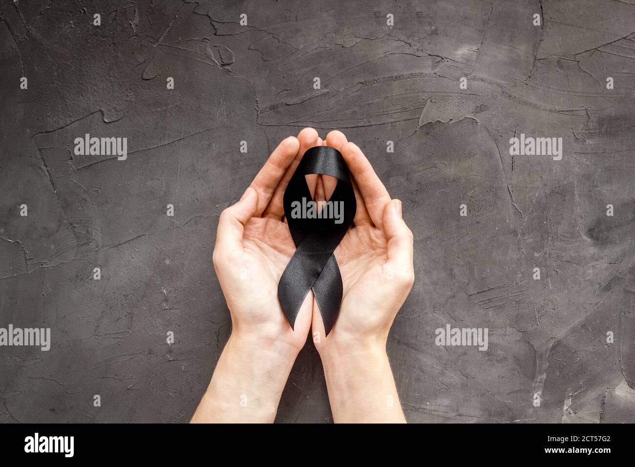 Hands holding black ribbon, top view. Funeral symbol Stock Photo - Alamy