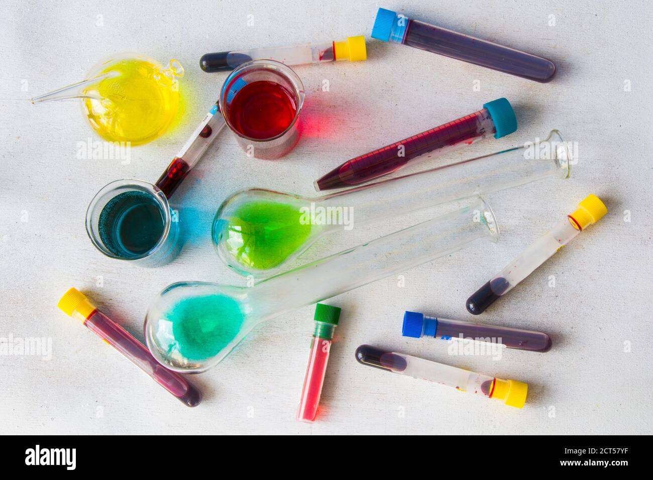 Laboratory glassware with colored reagents on the white background and ...