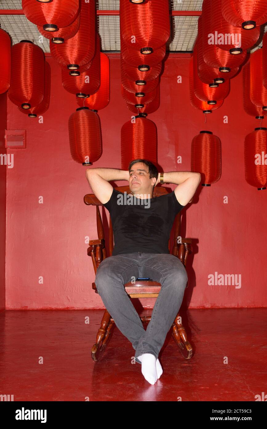 Handsome Persian man sitting and thinking on the chair inside artistic ...