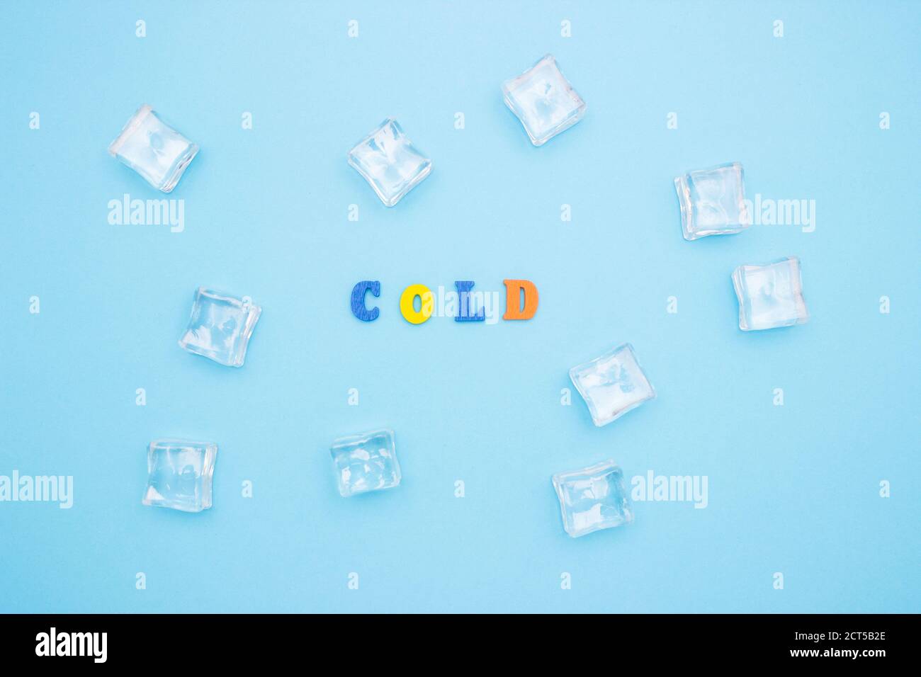 The word COLD on a blue background of wooden multicolored letters, ice ...