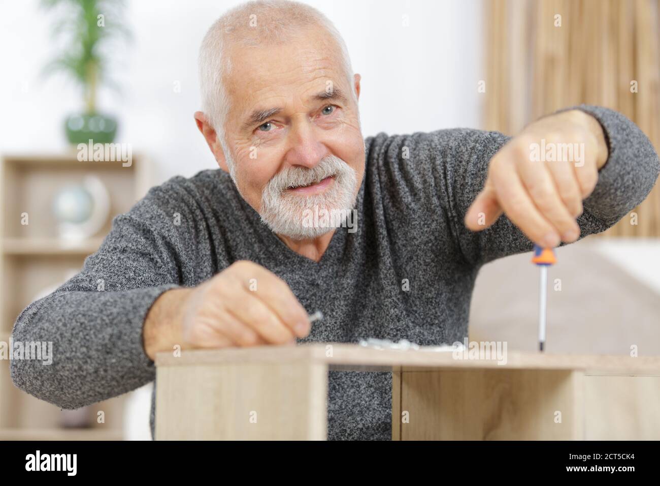 senior man is fixing a furniture Stock Photo - Alamy