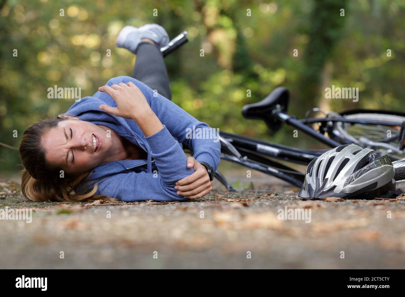 upset woman in pain fell off her bike Stock Photo - Alamy