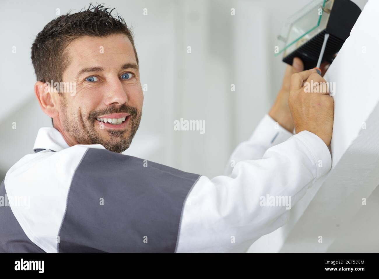 worker fixing an exit sign Stock Photo - Alamy