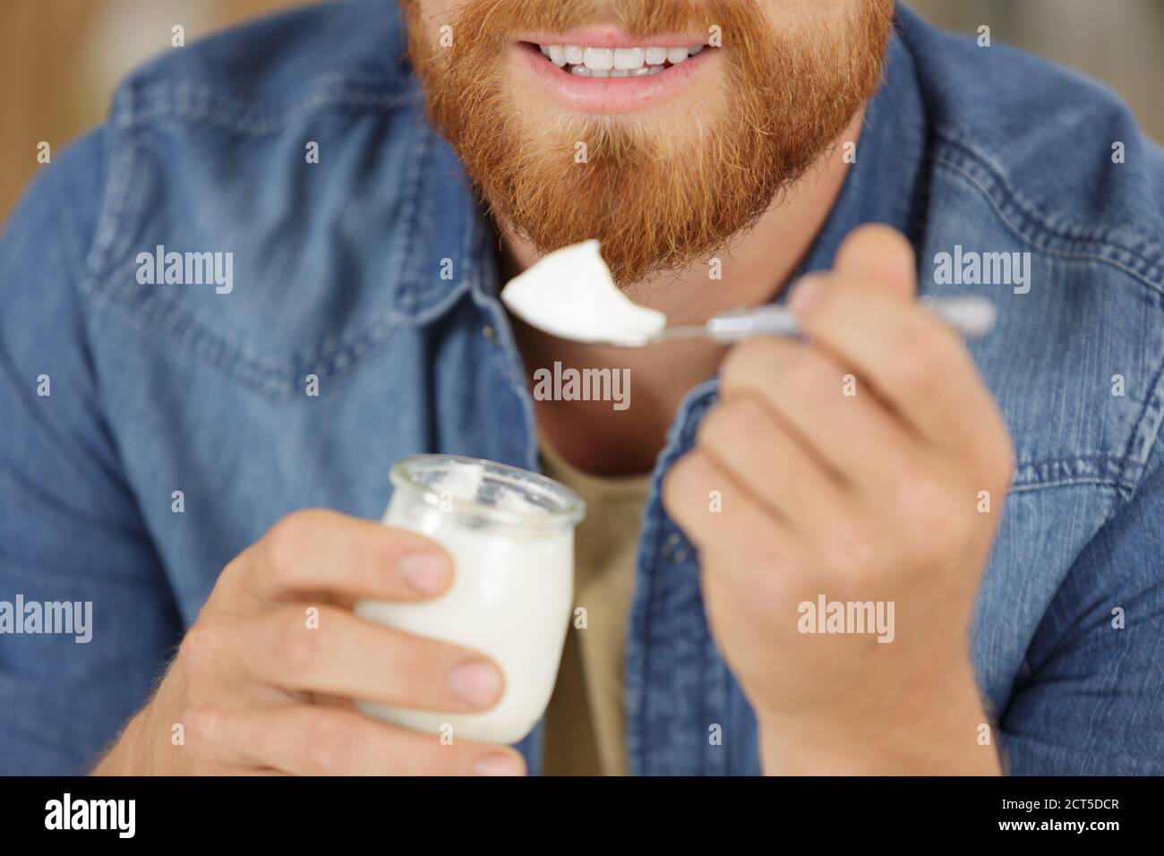 a man is eating yogurt Stock Photo - Alamy