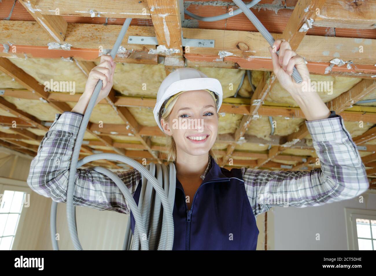 female construction worker installing cable ducting Stock Photo - Alamy