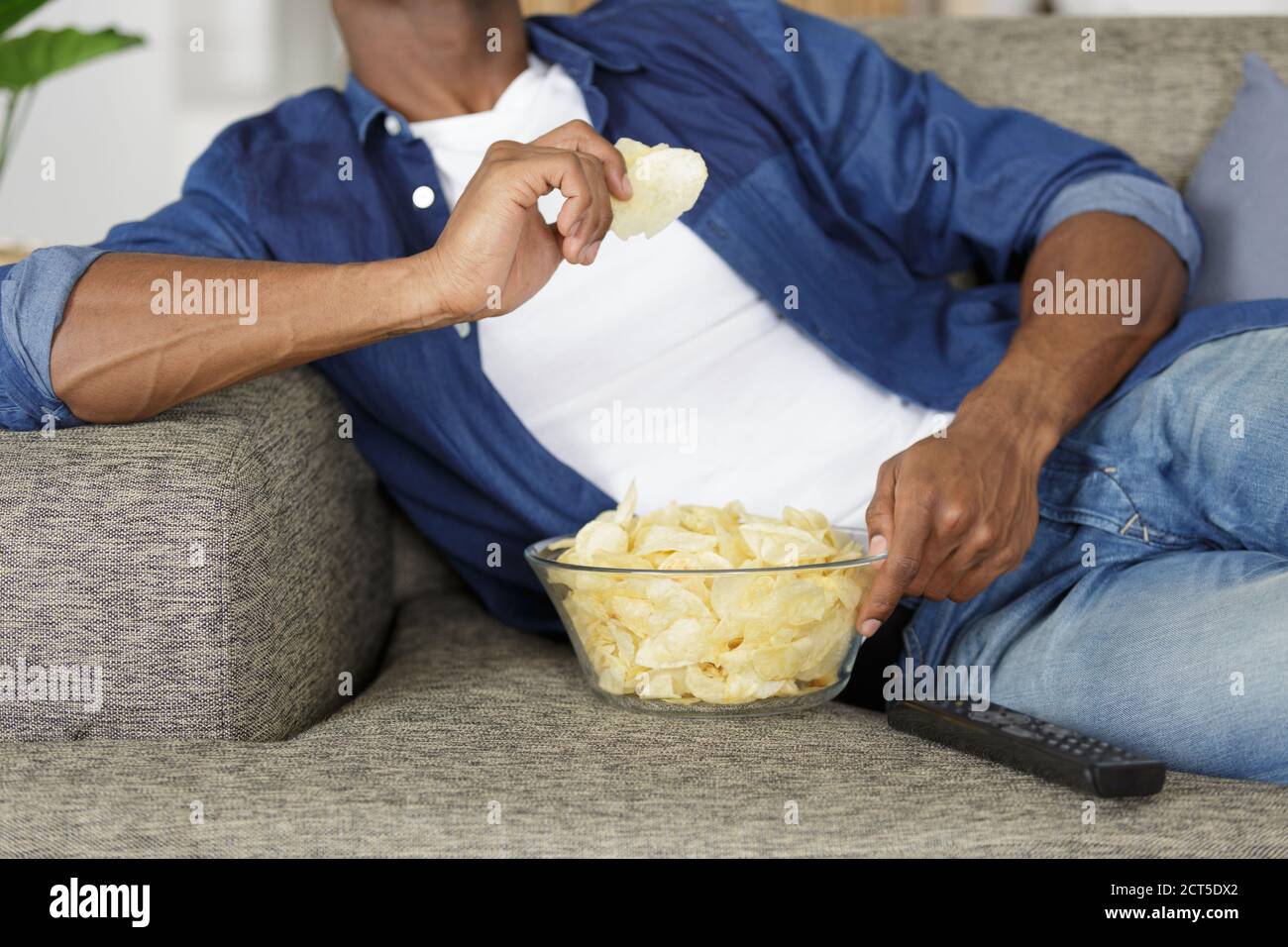 Man eating potato chips television hi-res stock photography and images ...