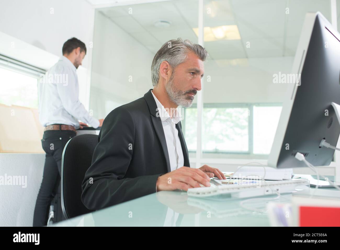 cheerful guy sitting in front of desktop computer Stock Photo - Alamy