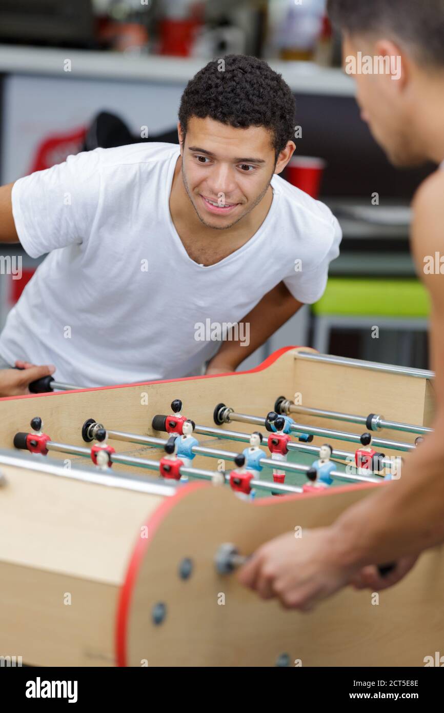 two young men playing table football Stock Photo - Alamy