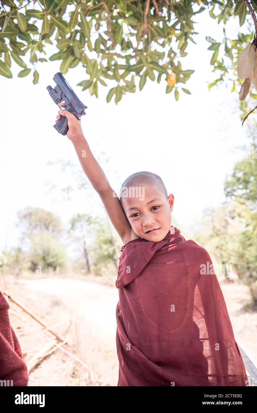 Novice Monk with a toy gun at a Buddhist Monastery between Inle Lake ...