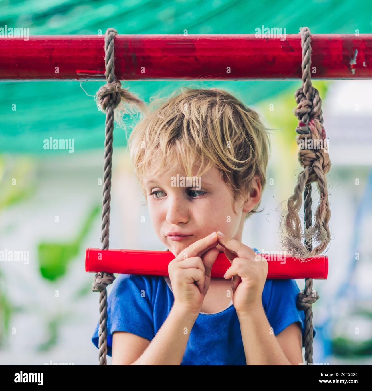 Close portrait Sad lonely freckled blue eyed cute blond little boy in t ...