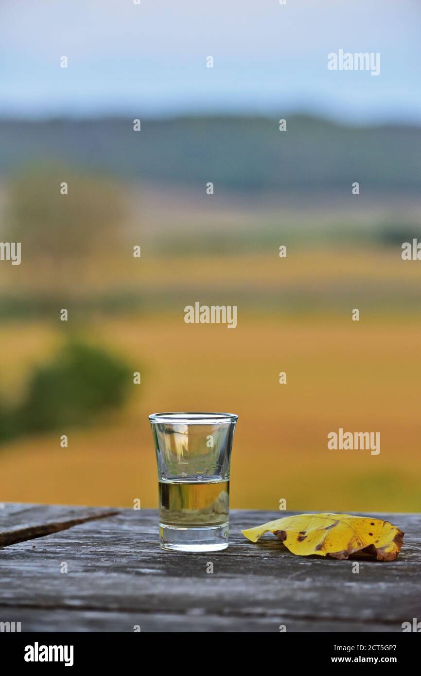 Glass of moonshine with rural background on an autumn evening in ...