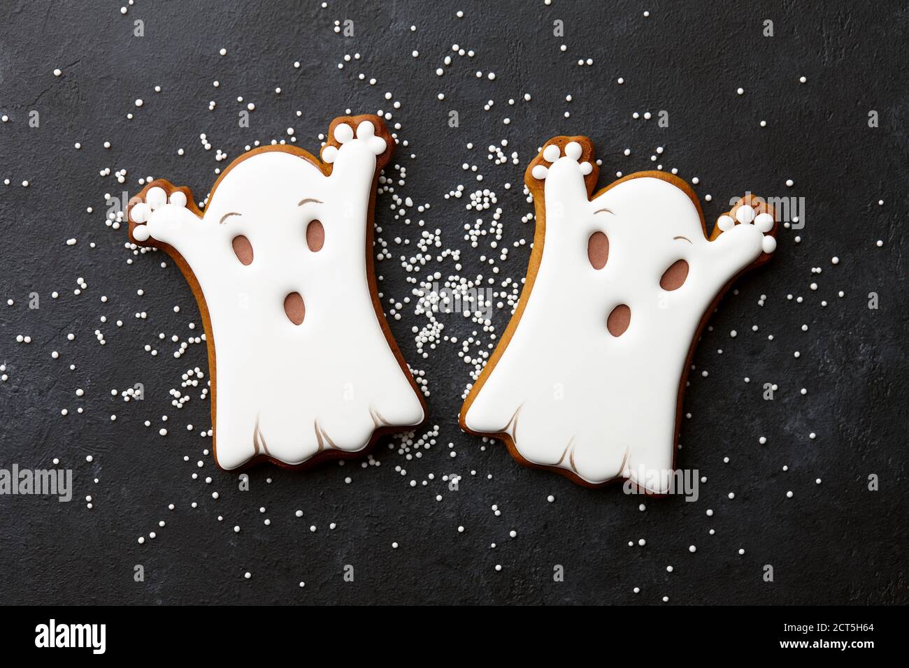 Halloween gingerbread biscuits on black background. Funny white ghosts ...