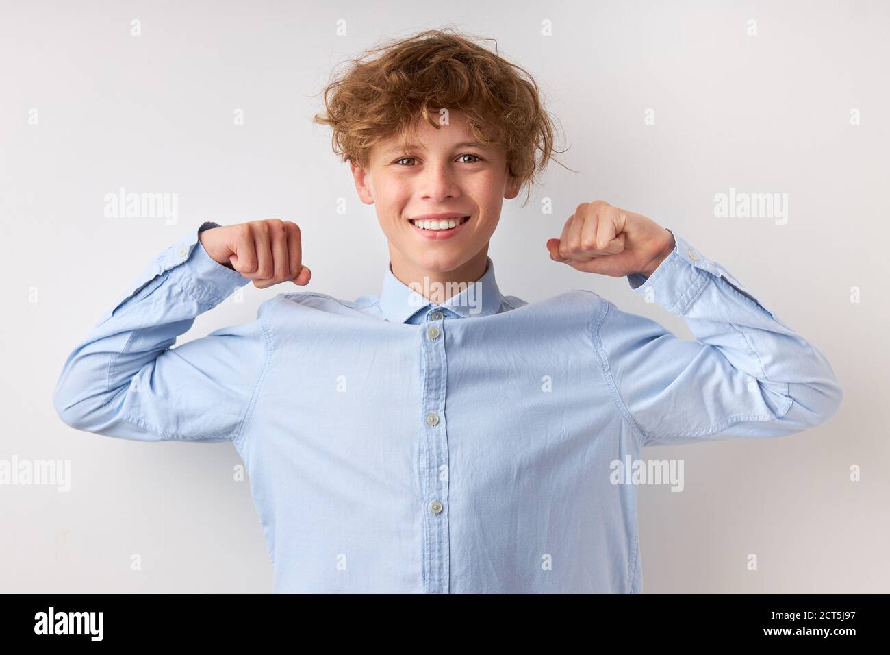 smiling caucasian boy show arm muscles, strong boy look at camera ...