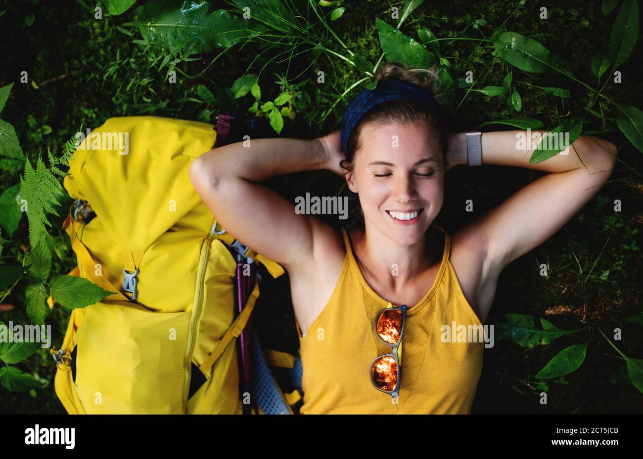 Top view of woman hiker lying on the ground outdoors in forest, resting ...