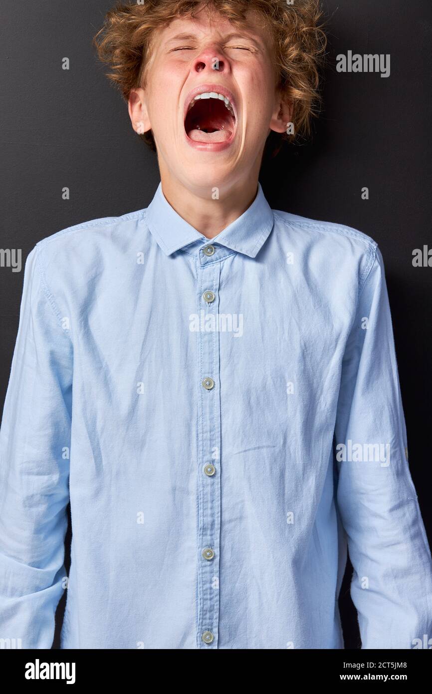 emotional caucasian teen boy is screaming, affective boy has an ...