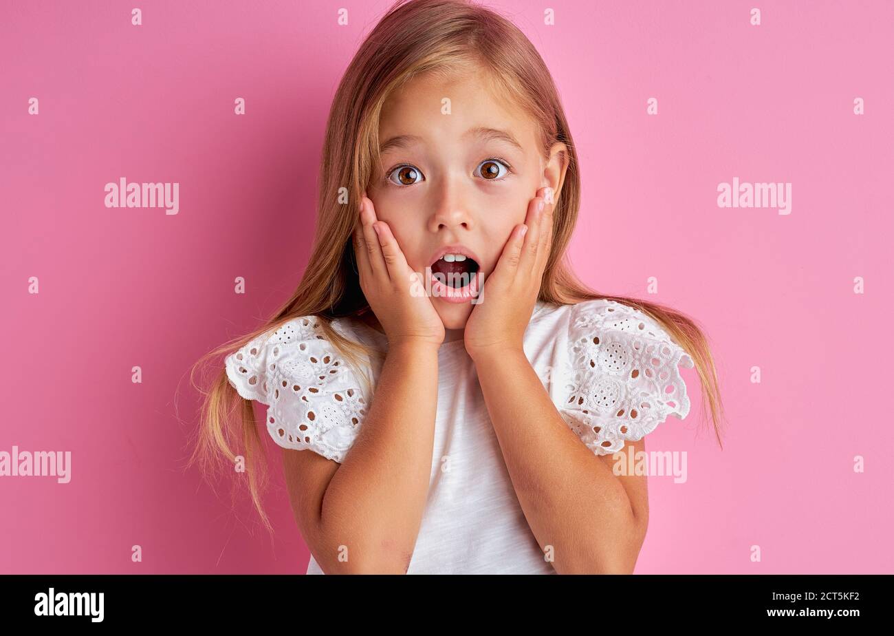 portrait of little caucasian girl in shock, she is surprised by ...