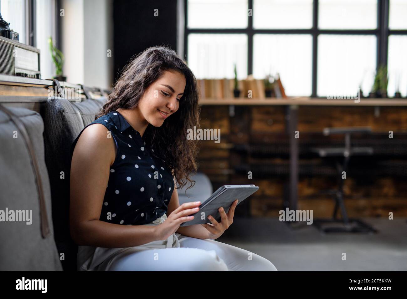 Portrait of young businesswoman indoors in office, using tablet Stock ...