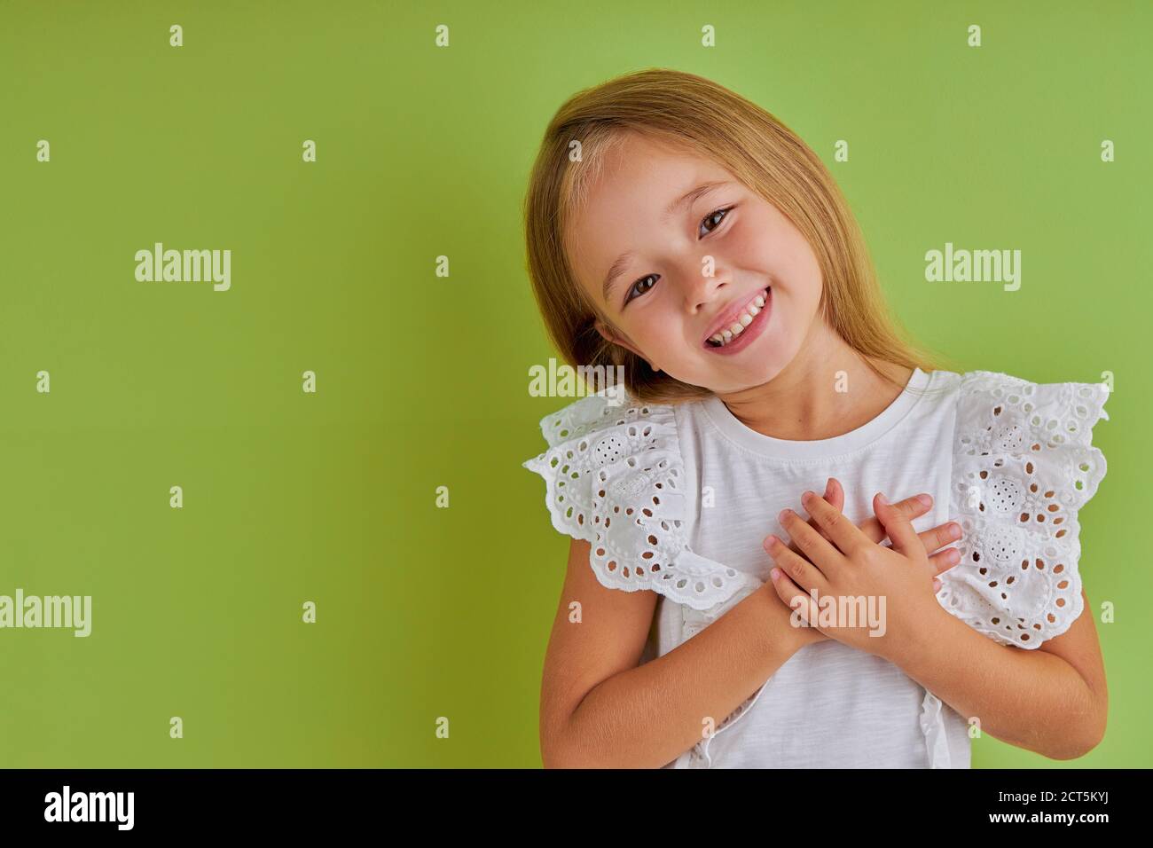 kind caucasian little girl say thanks at camera, isolated over green ...