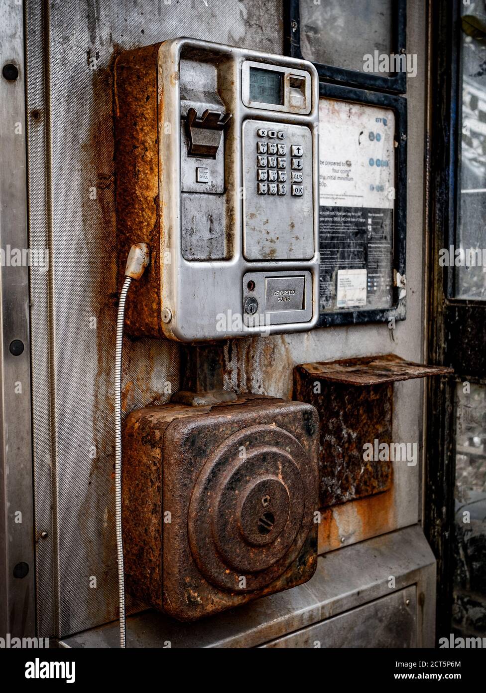 Out of order rusty, neglected, weathered Public telephone box with the ...