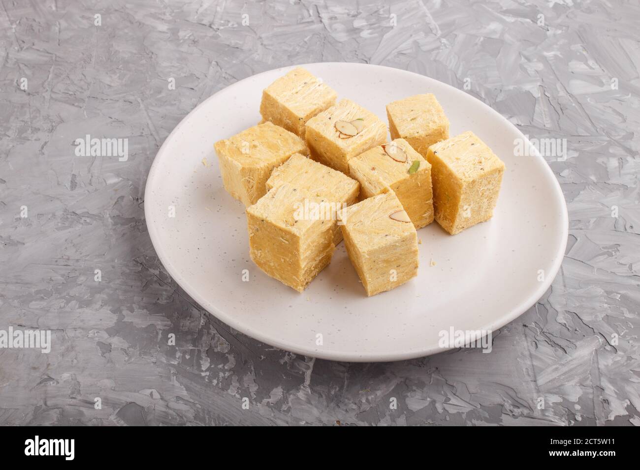 traditional indian candy soan papdi in white plate with almond and ...