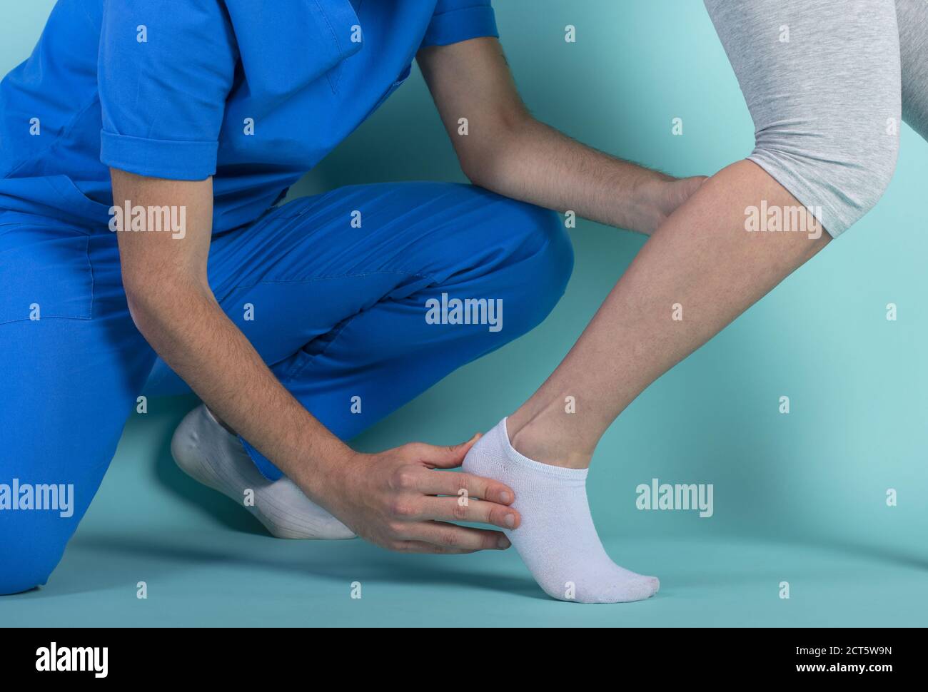 woman performs exercises with a physiotherapist. Cyan background Stock ...
