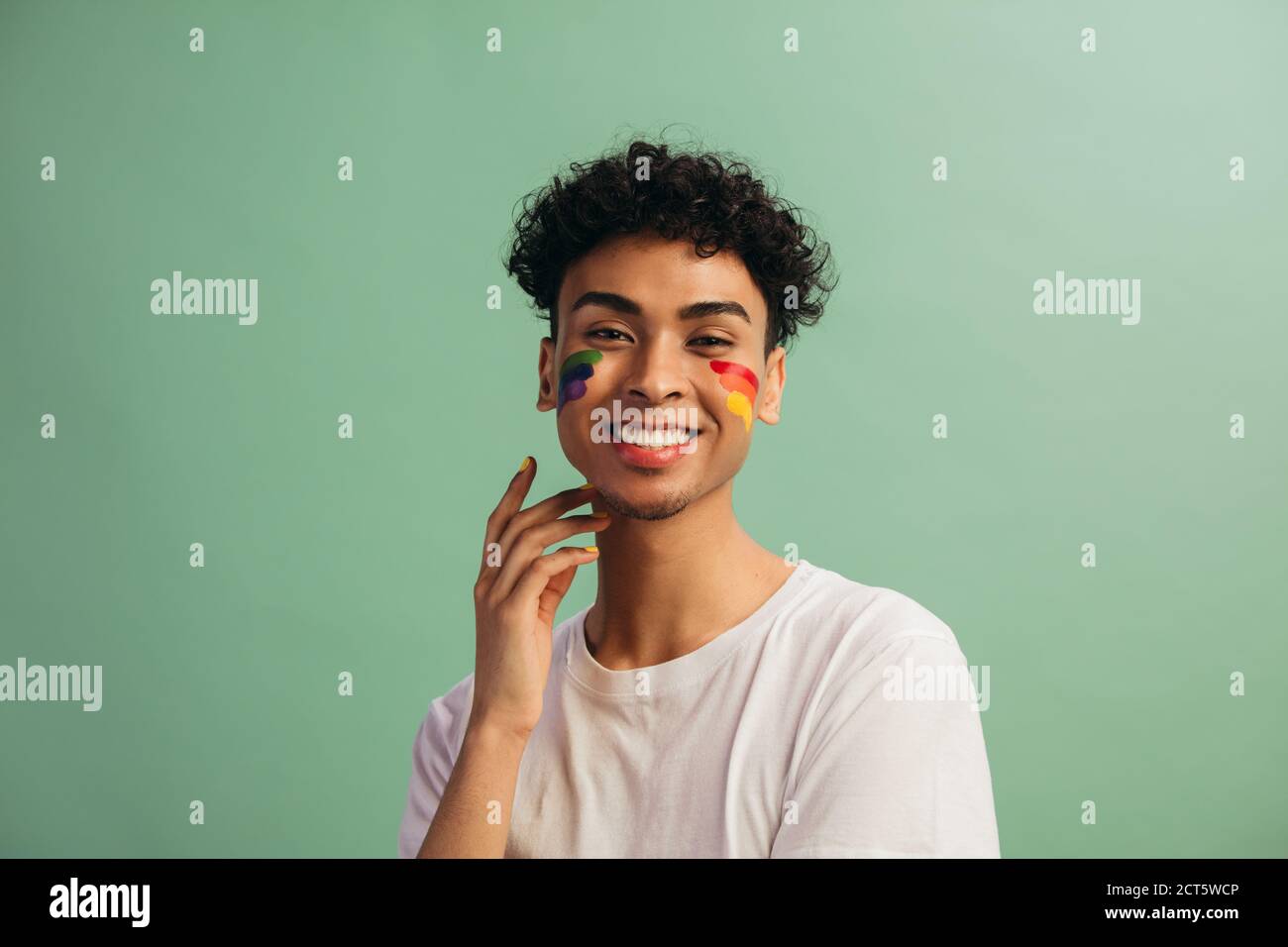 Man with rainbow face paint celebrates gay pride. Gay man standing on ...