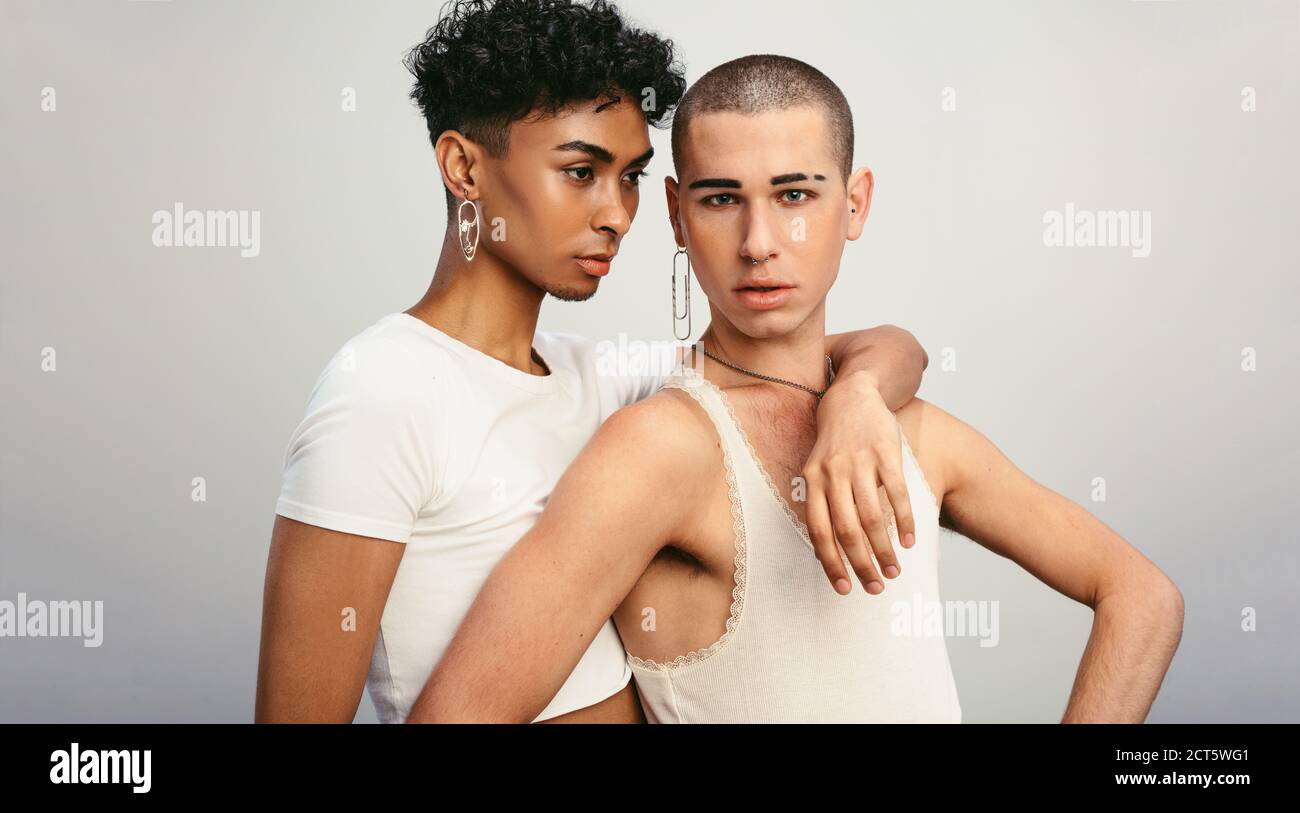 Two androgynous men in white tops posing together. Gay community ...