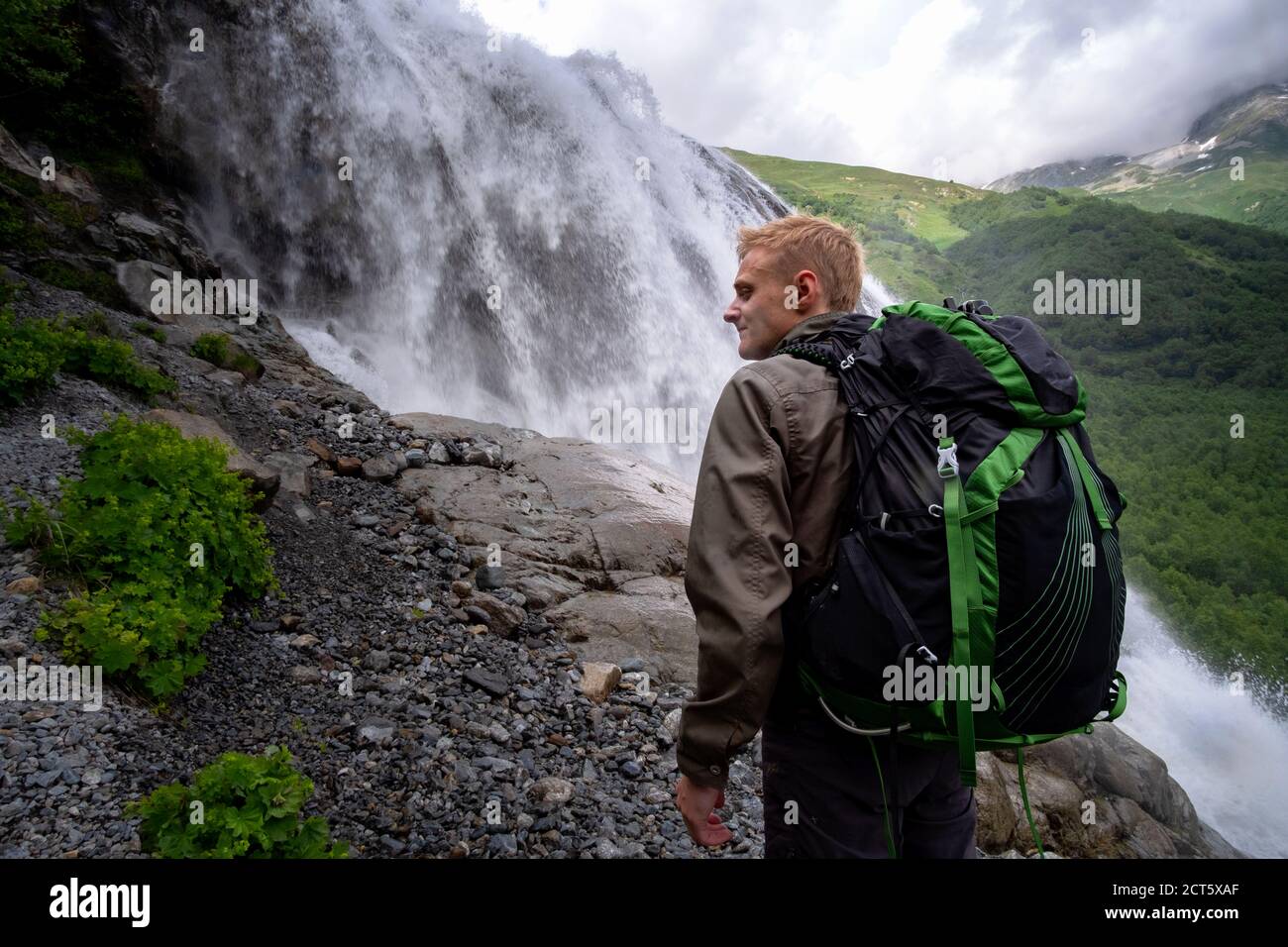 Man hiking with backpack looking at waterfall. Travel Lifestyle ...