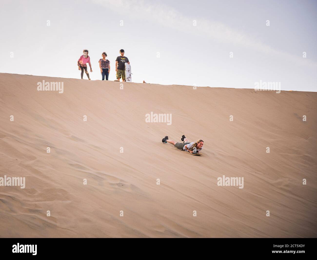 Sand boarding on dunes in the desert at Huacachina, Ica Region, Peru ...