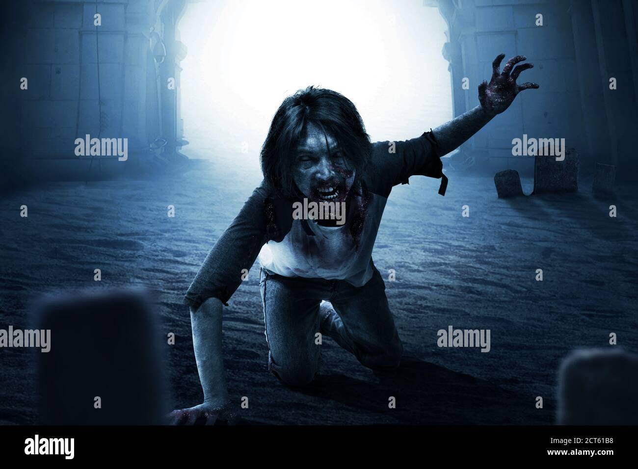 Scary zombie with blood and wound on his body crawling on the graveyard ...