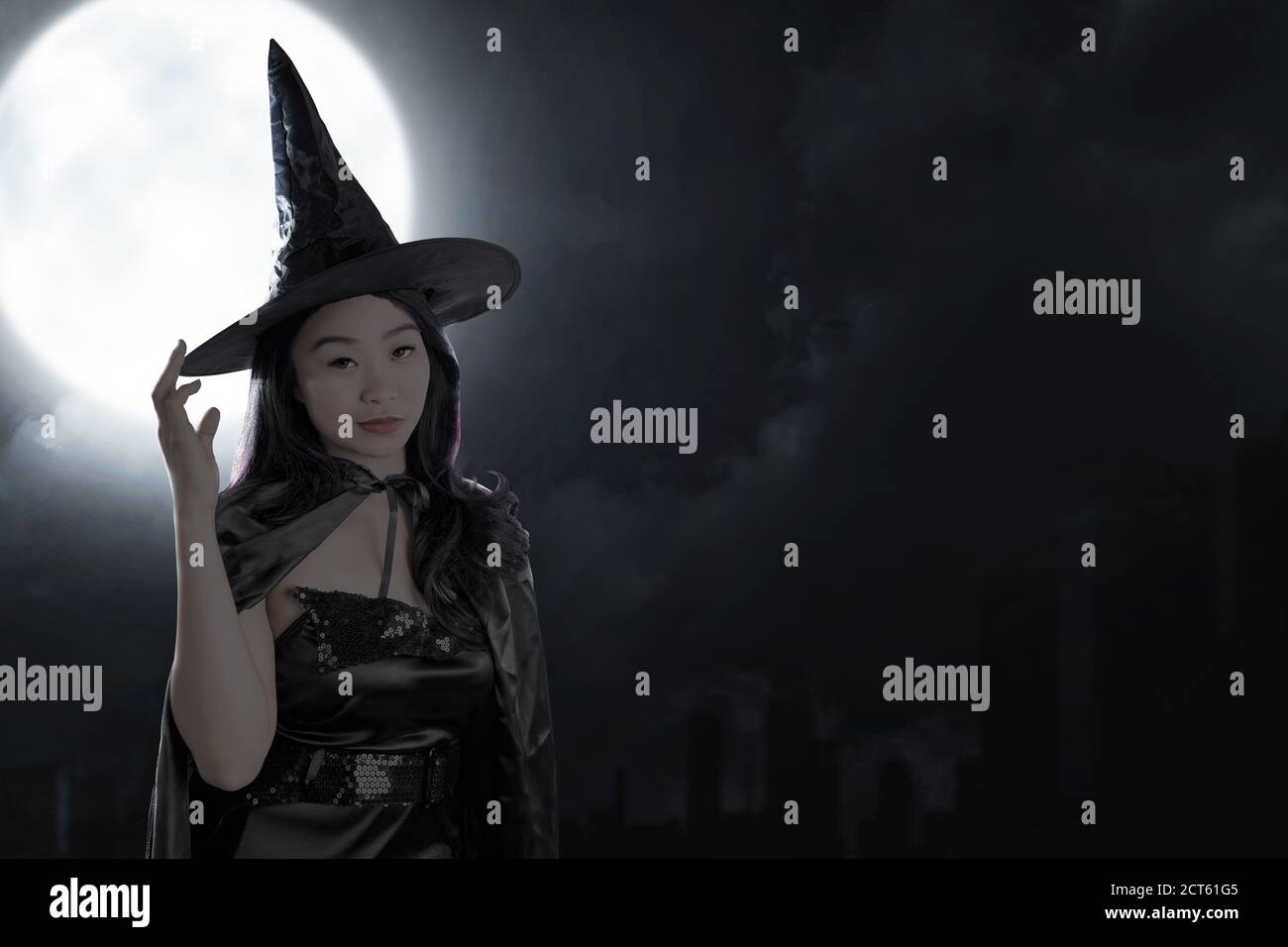 Asian witch woman with a hat standing with the night scene background ...