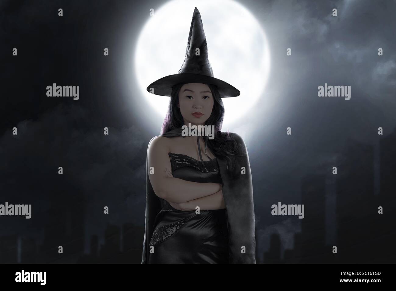 Asian witch woman with a hat standing with the night scene background ...