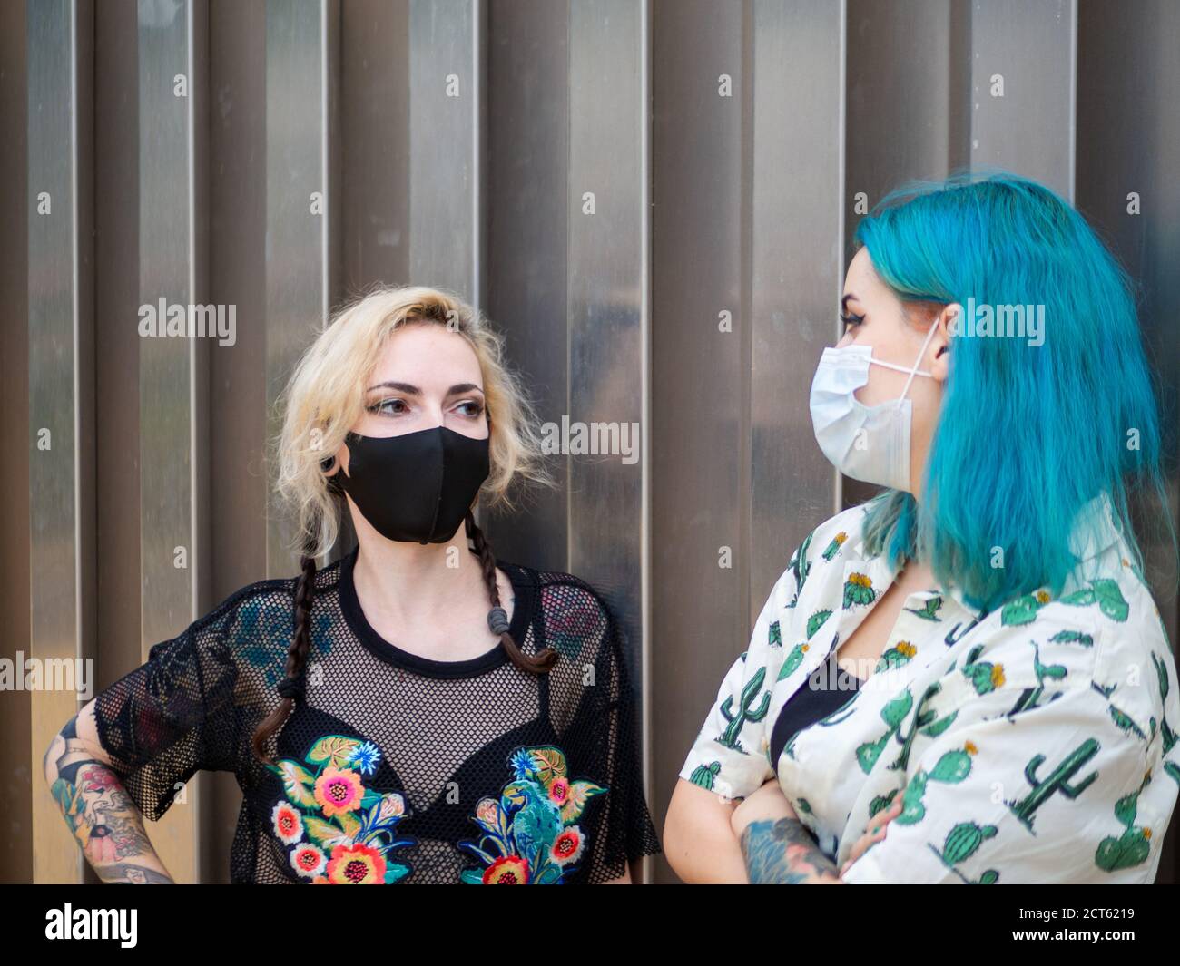 Shot of two women wearing medical masks talking to each other - new ...