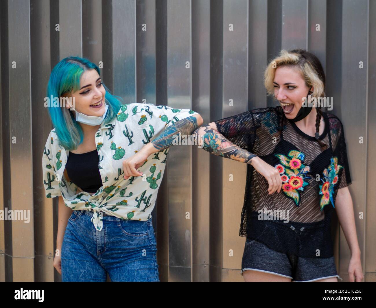 Shot of two women wearing medical masks talking to each other - new ...