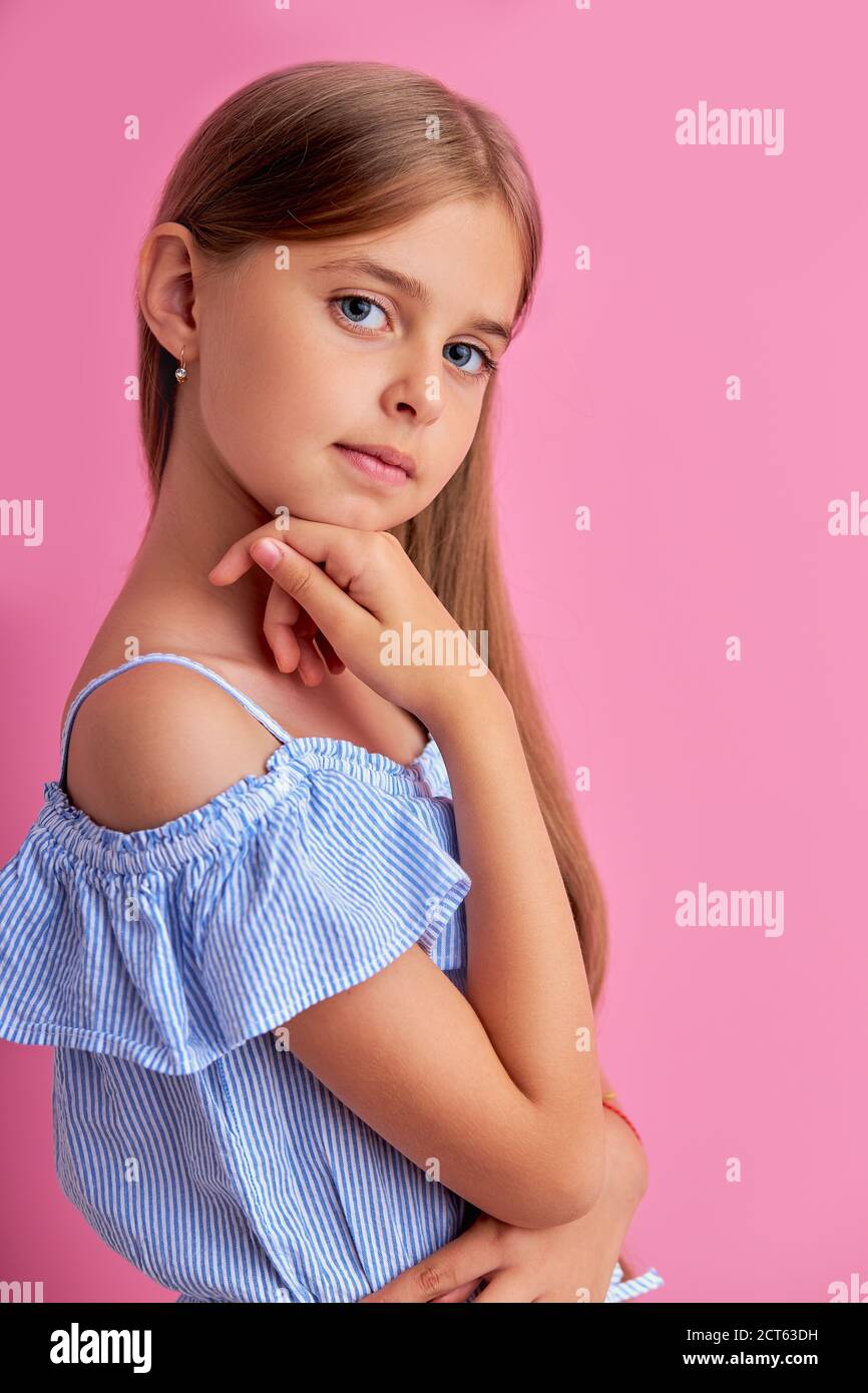 litttle caucasian fashion model girl in dress isolated over pink ...