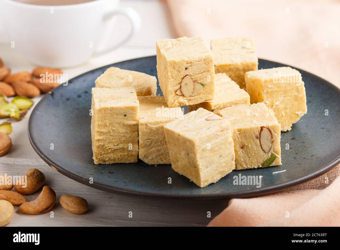 traditional indian candy soan papdi in a blue ceramic plate with almond ...