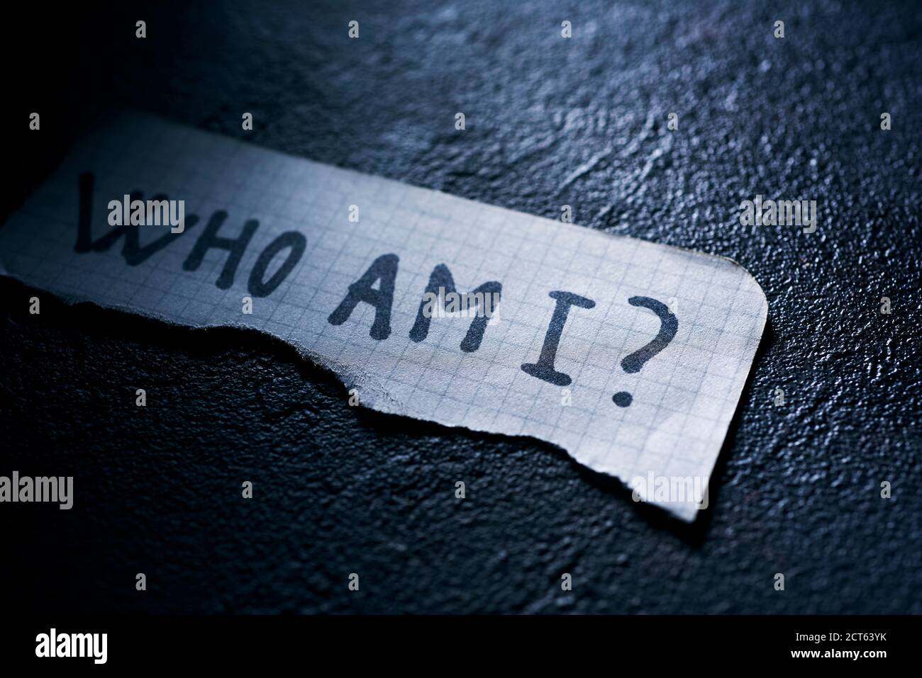 a piece of paper with the question who am I written in it, on a black ...