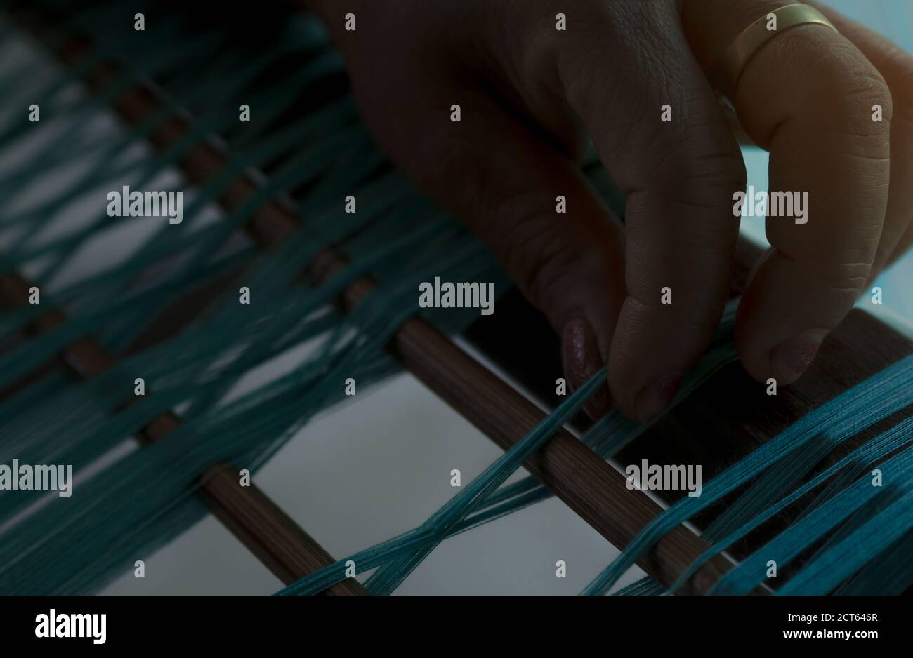 Selective focus on woman hand holding green cotton strands on weaving ...
