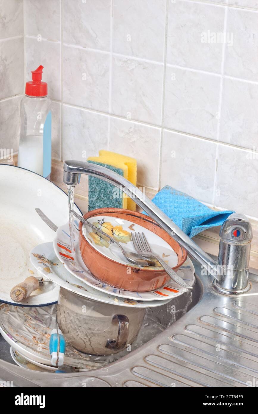 Dirty dishes in kitchen sink with running tap water Stock Photo - Alamy