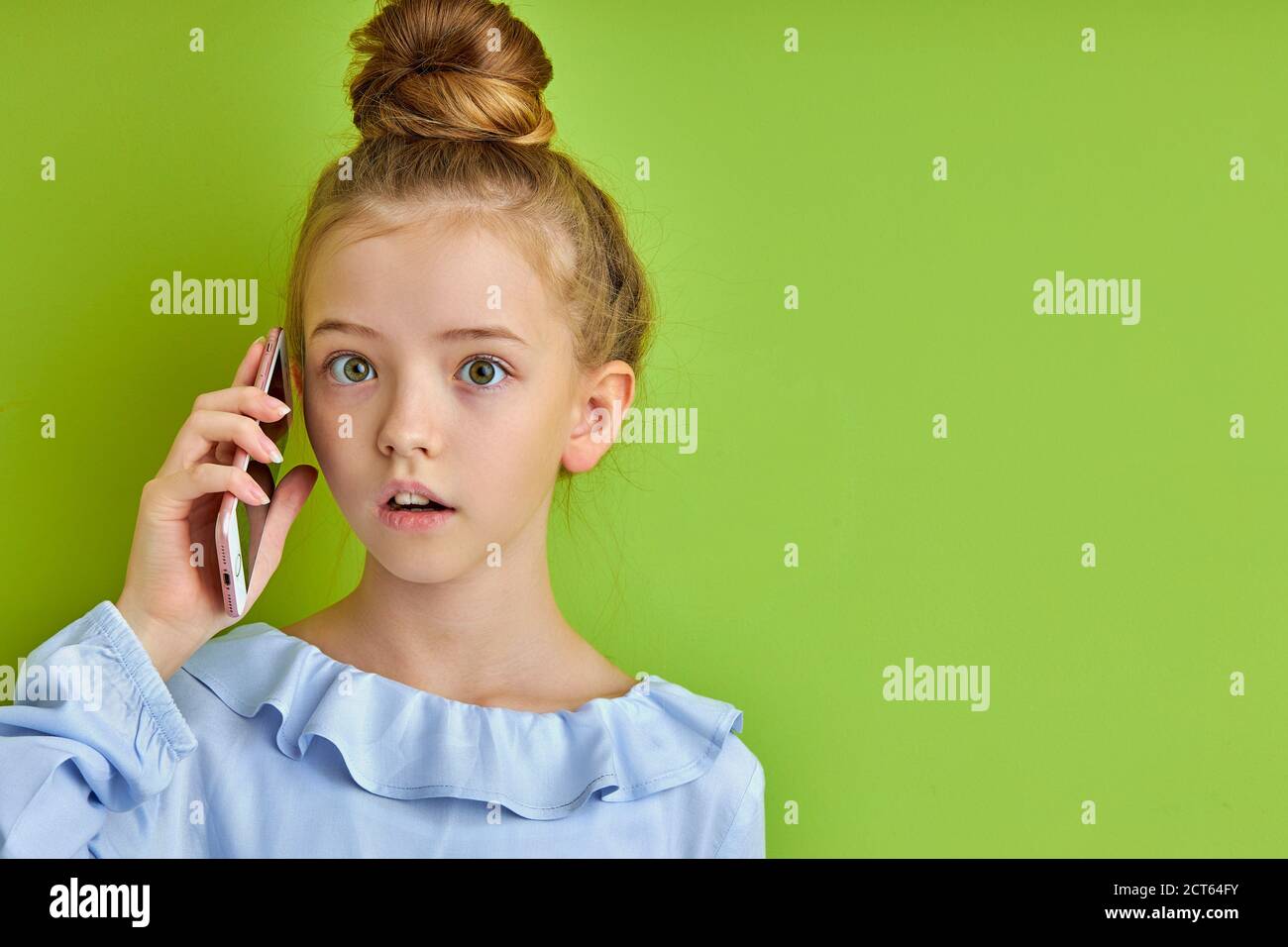 kid girl is surprised by news hearing on phone, stay in shock while ...