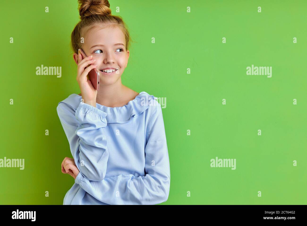 sweet caucasian child girl talk on phone isolated in studio with green ...