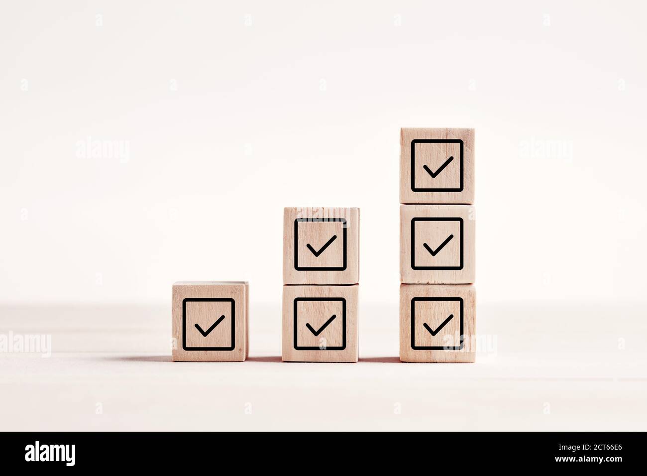 Check mark on wooden blocks against blue background with copy space ...