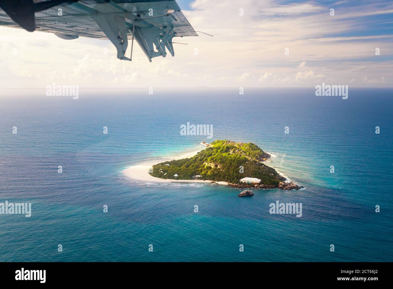 Aerial view of small island of Seychelles, with part of airplane wing ...