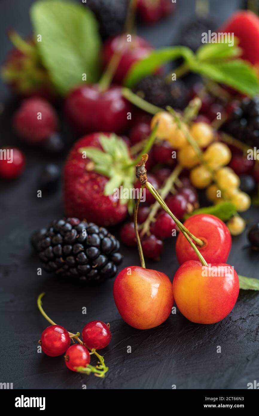 Mixed berries on a dark background with selected focus. Strawberries ...