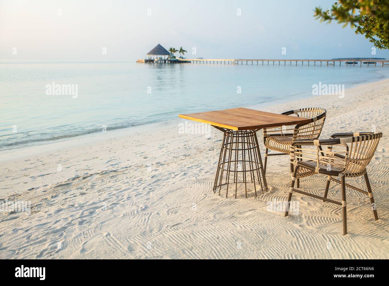 Wooden table and chairs on tropical beach by the water in tropical ...