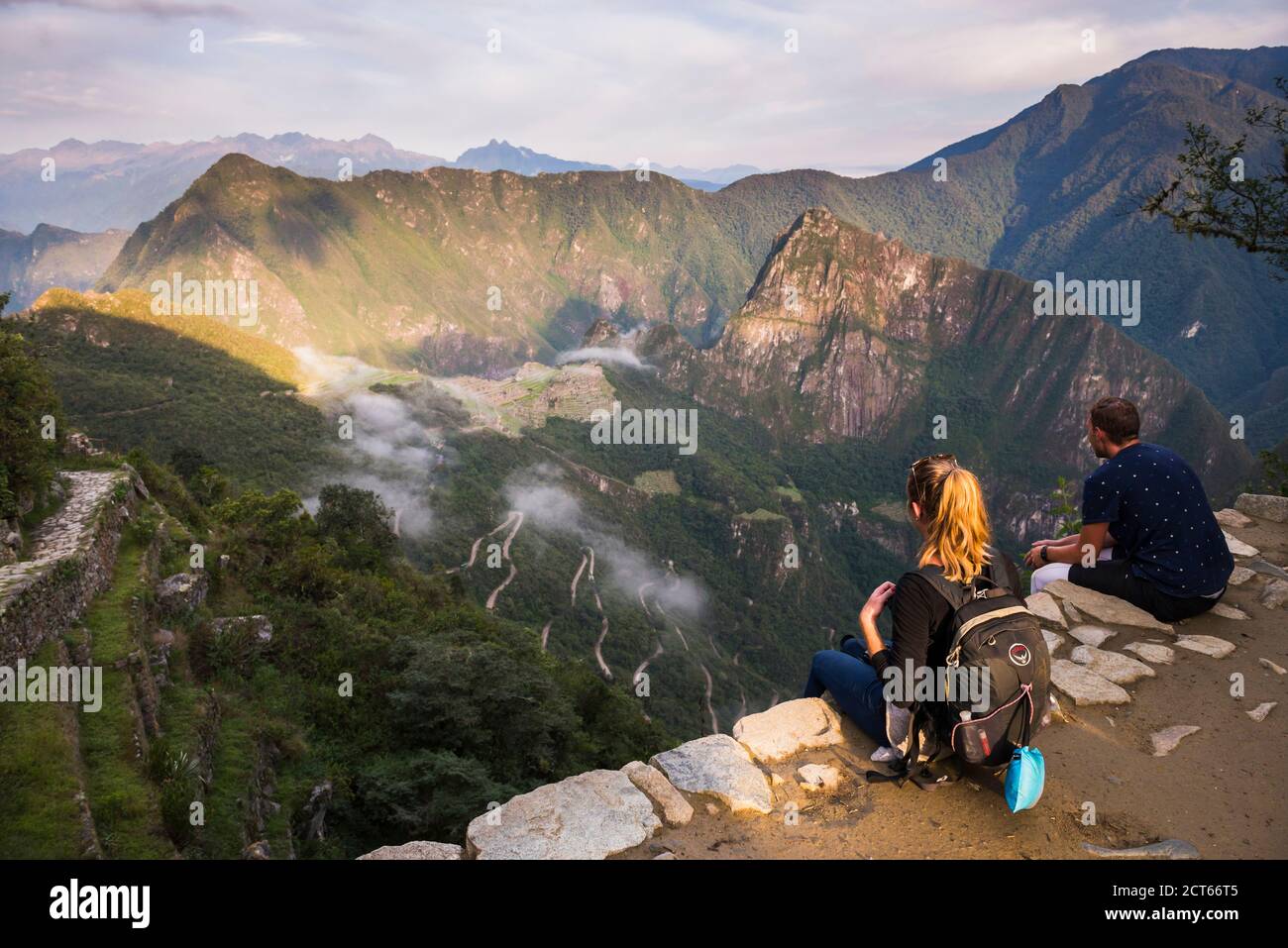 Tourist watching sunrise over Machu Picchu, the ruins of an Inca city ...
