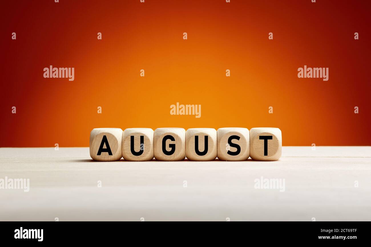 The month August written on wooden cubes with summer background with ...